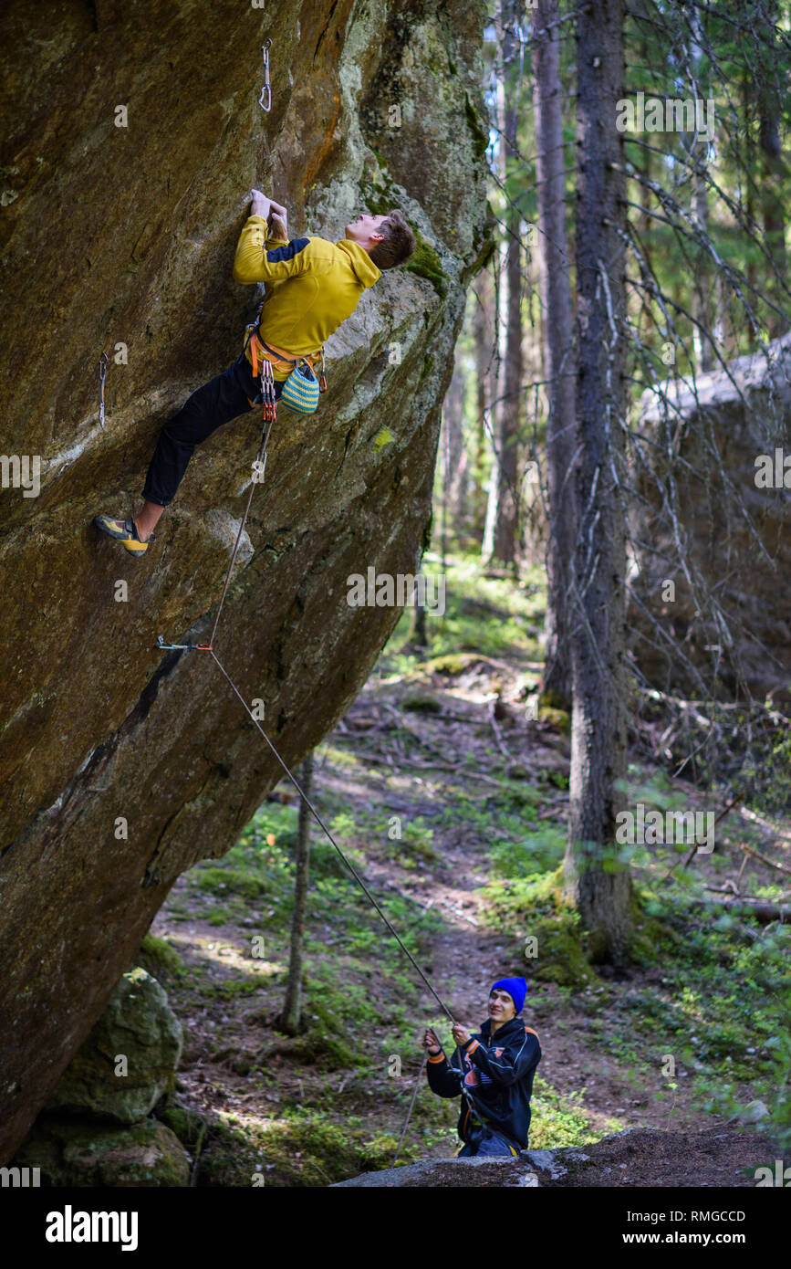Rock climber ascending a challenging cliff. Extreme sport climbing ...
