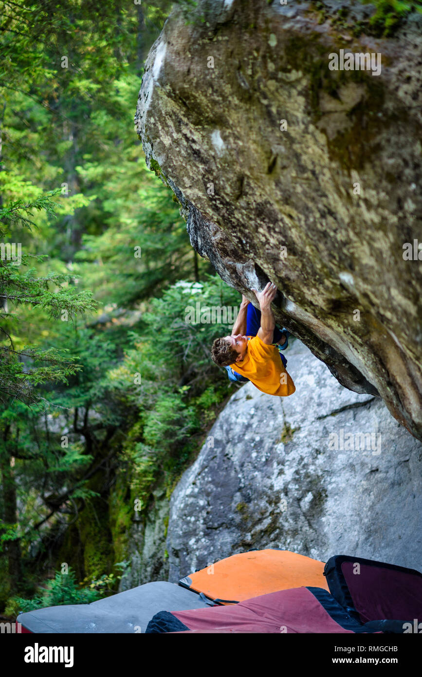 Strong climber on a challenging boulder problem. Magic wood ...