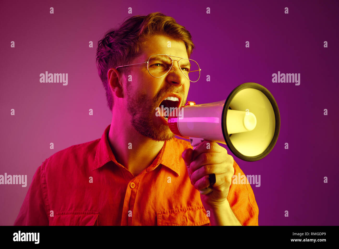 man making announcement with megaphone at gold studio Stock Photo - Alamy