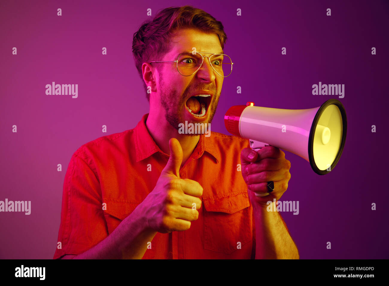 man making announcement with megaphone at gold studio Stock Photo - Alamy
