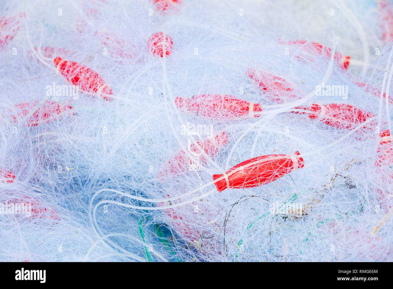 Fishing nets in pile mixed with round red floaters Stock Photo - Alamy