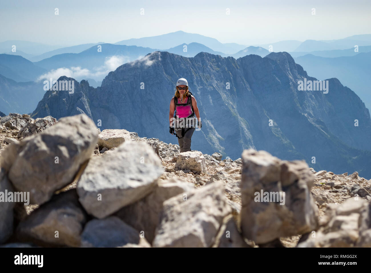 Female climber finishing a via ferrata route on Veliki Mangart (Mangrt ...