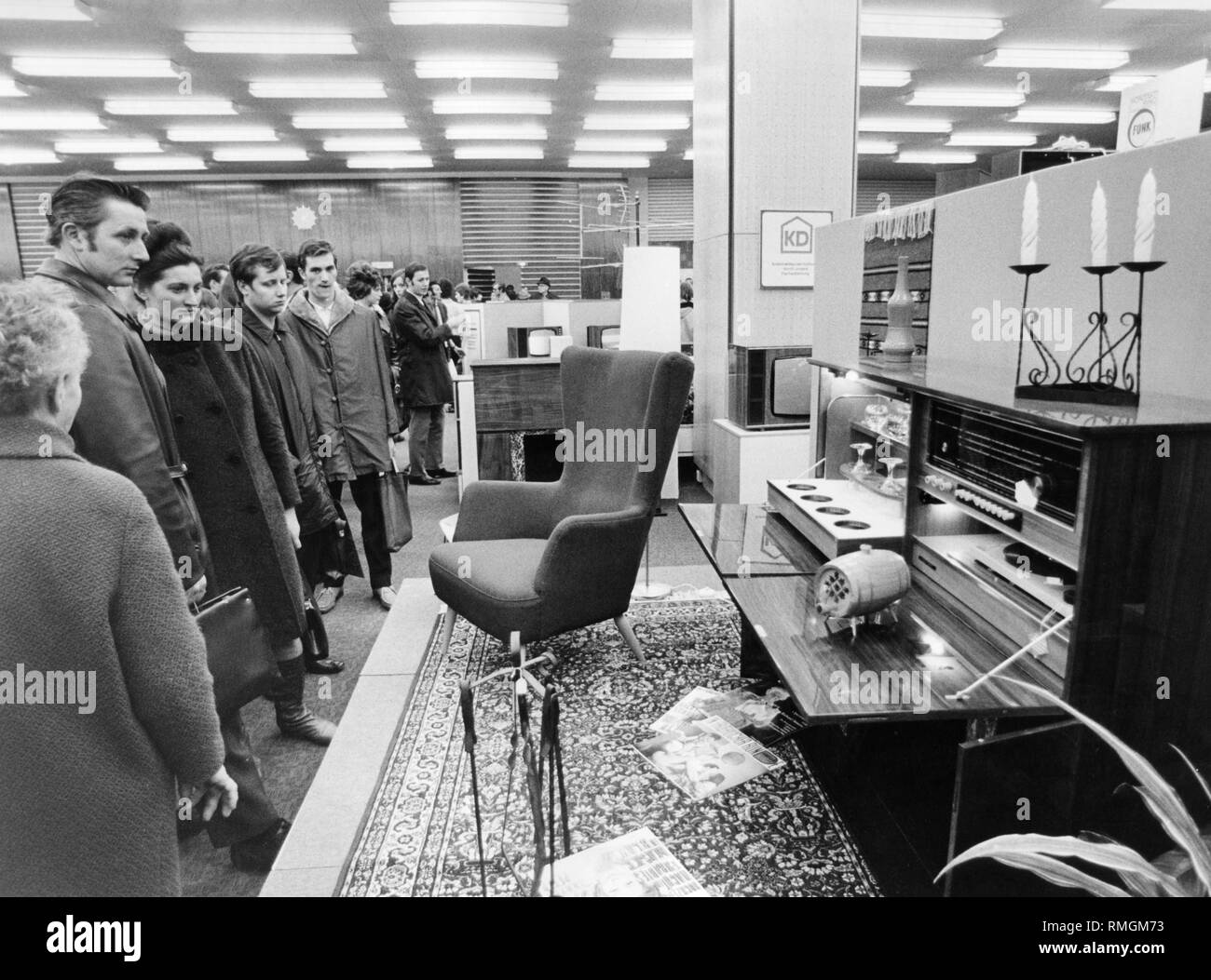 Customers look at the exhibited goods, among others a record player, in ...
