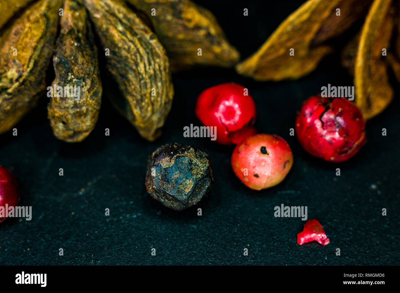 Star anise and multi-colored balls fragrant peppers on a black ...