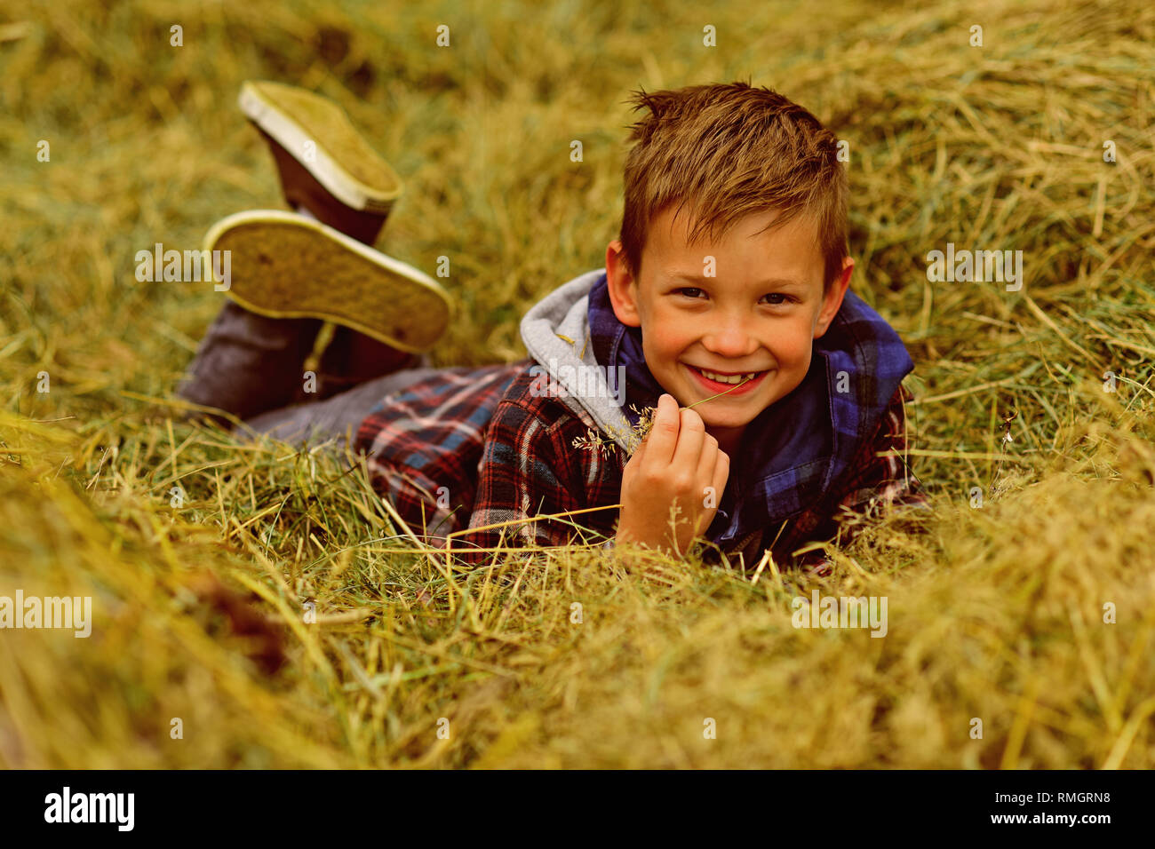 The body needs its rest. Healthy boy. Small boy relax in hay. Small boy ...