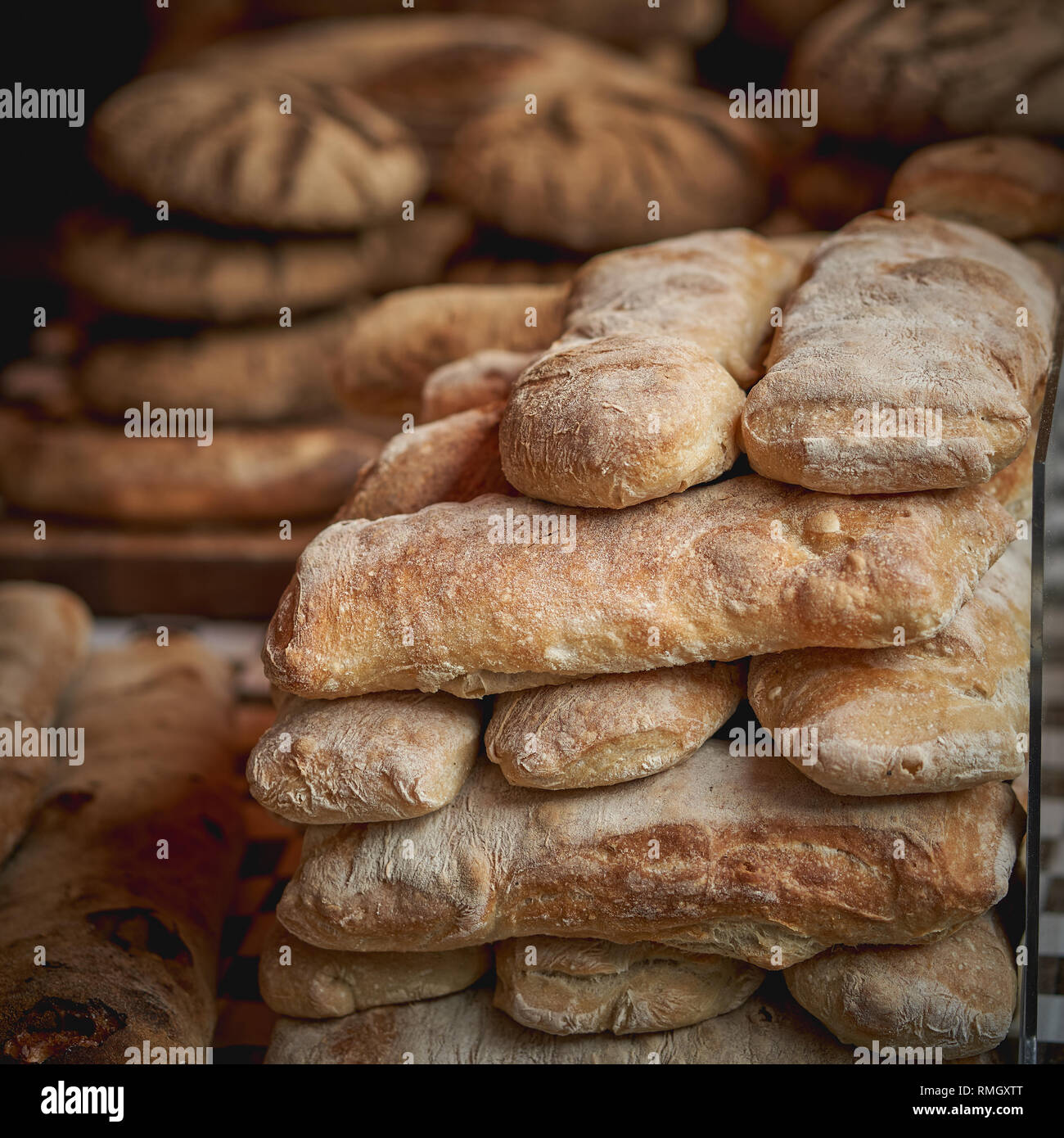 Stacks of organic brown and white sourdough bread loaves on sale in a ...