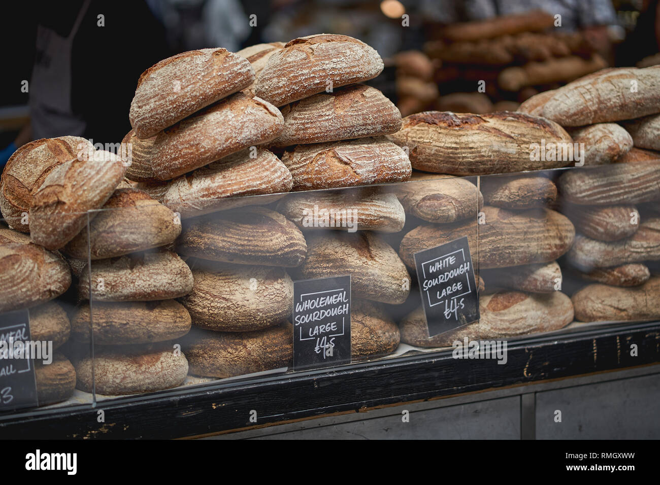 Stacks of organic brown and white sourdough bread loaves on sale in a ...