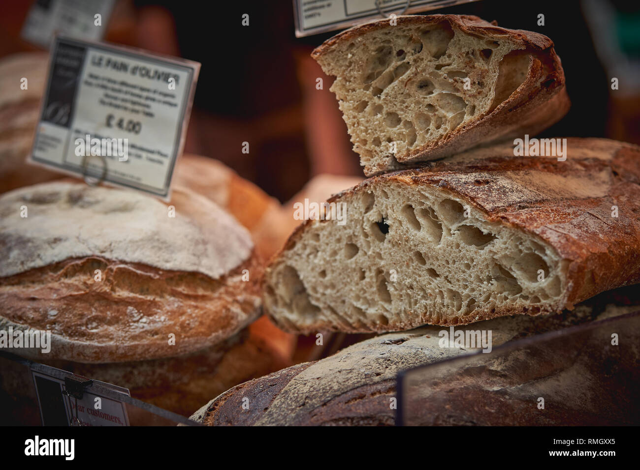 Stacks of organic brown and white sourdough bread loaves on sale in a ...