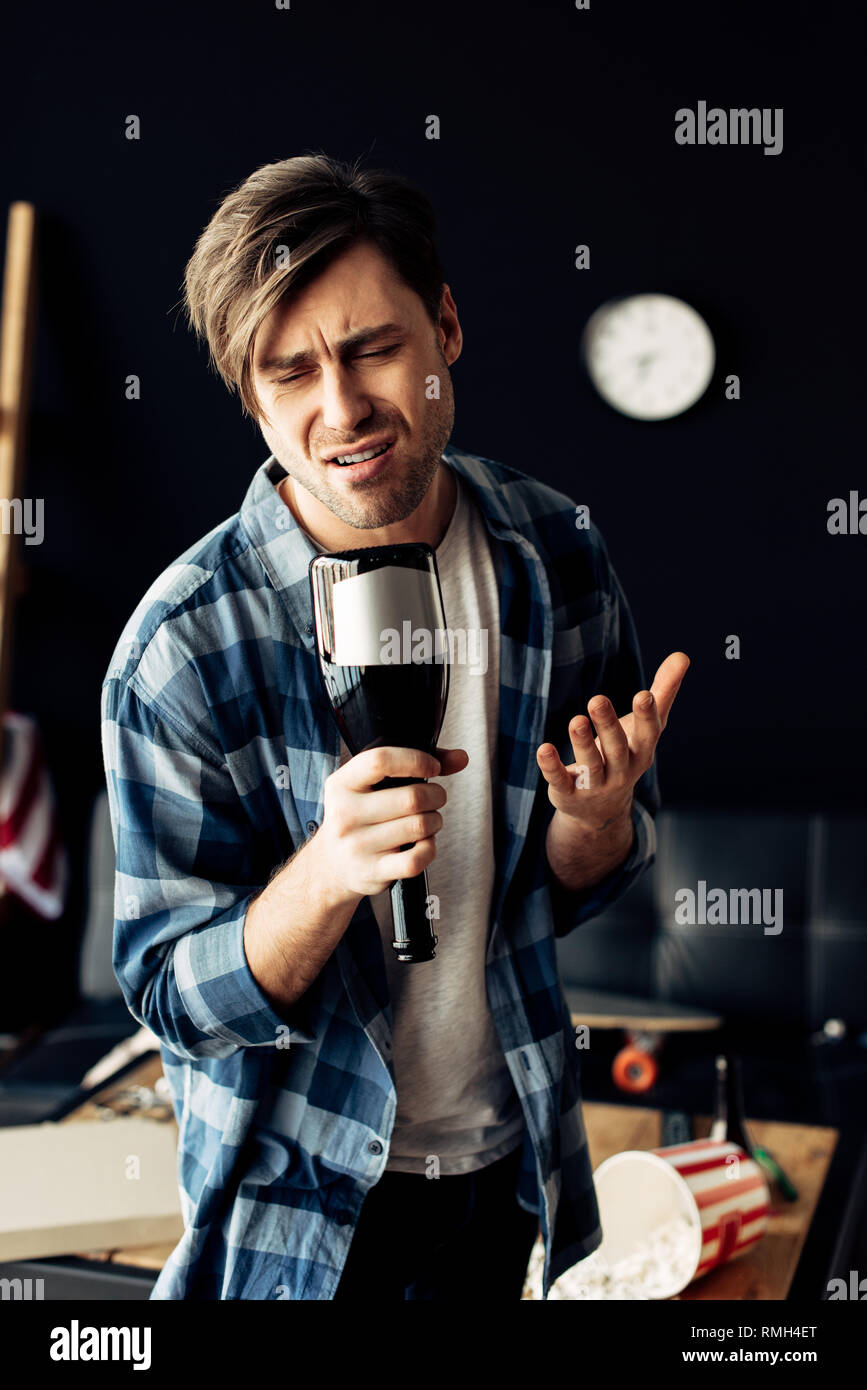 drunk man holding bottle and singing at home Stock Photo - Alamy