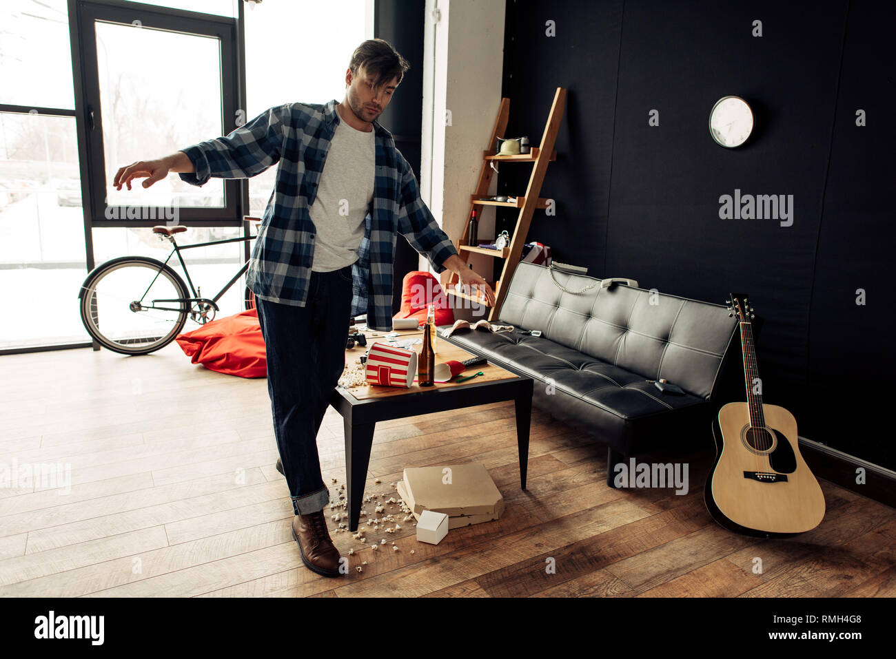 drunk sleepy man standing near coffee table after party at home Stock ...