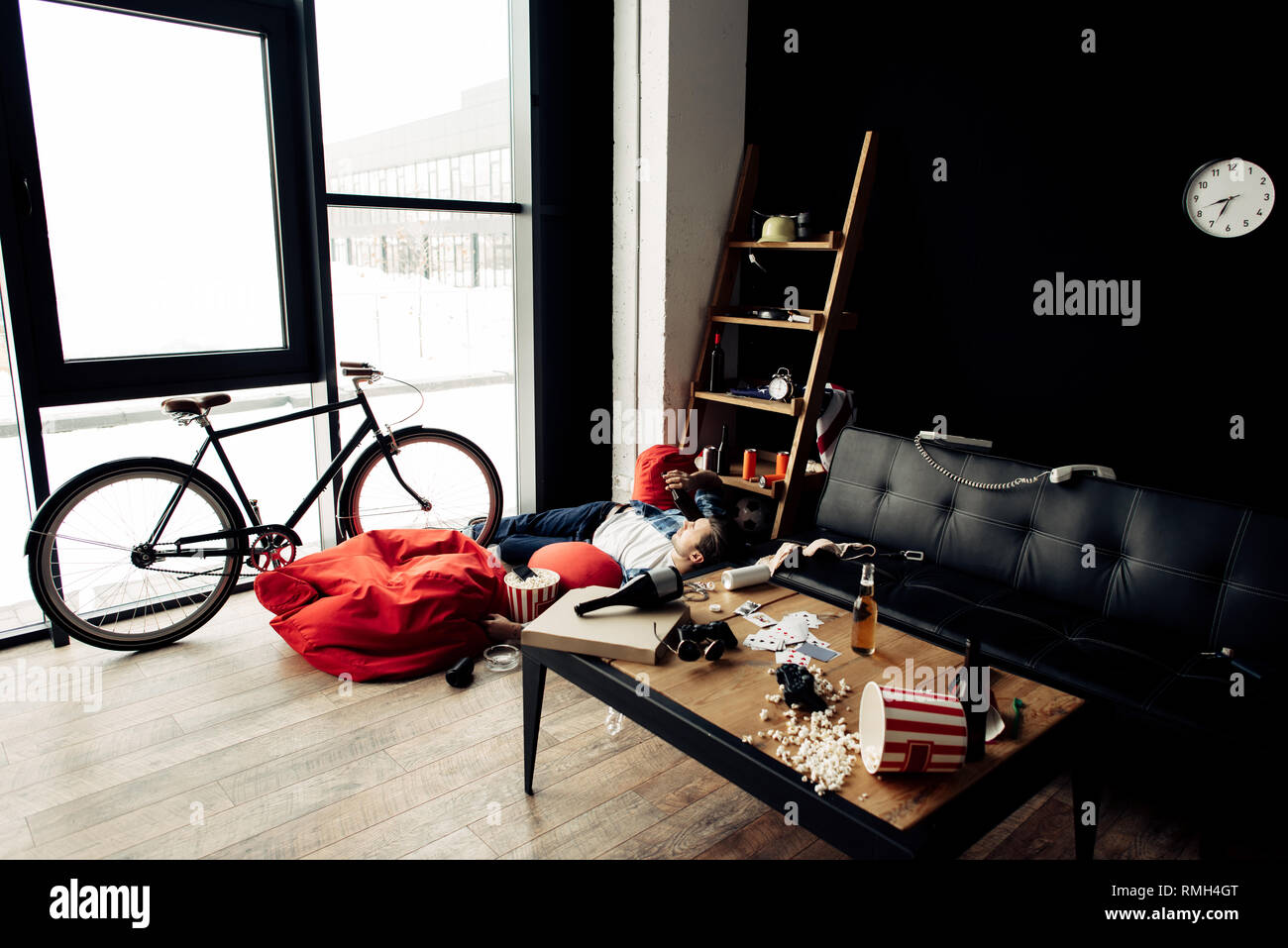 messy living room with bottles and popcorn on coffee table Stock Photo ...