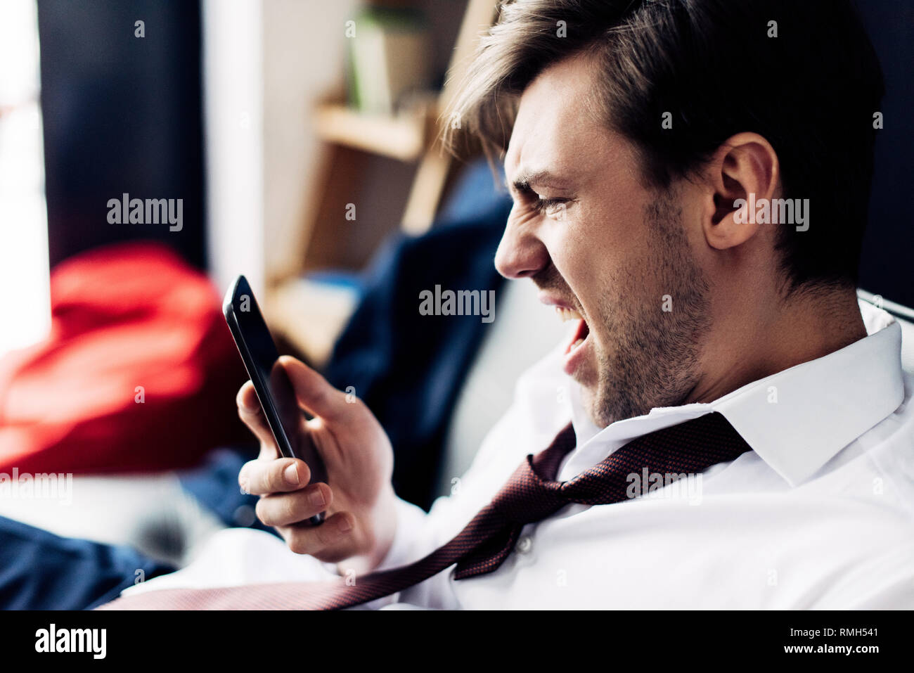 angry man in suit screaming at smartphone after party Stock Photo - Alamy