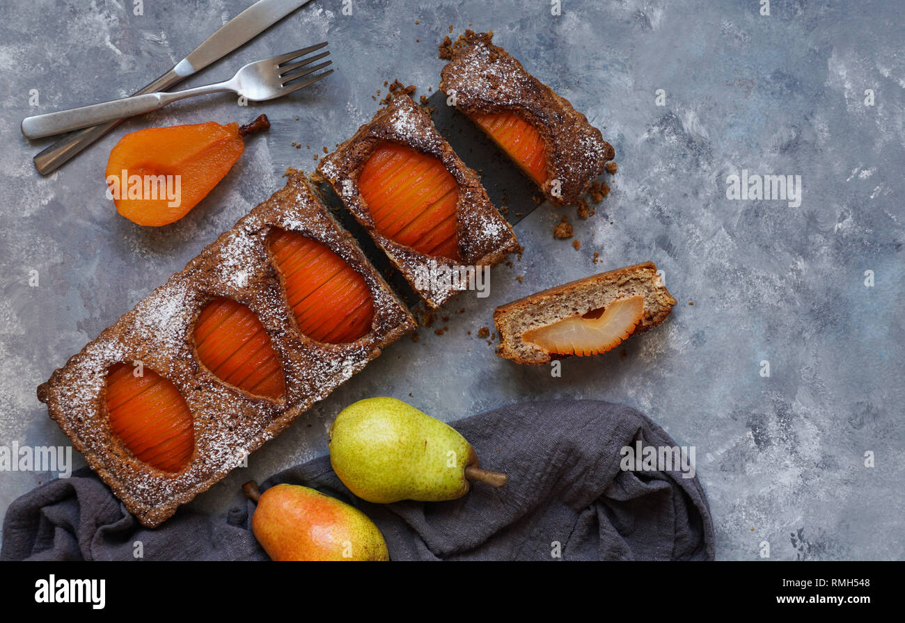 From above cutlery and pear frangipane tart near fresh fruits and ...