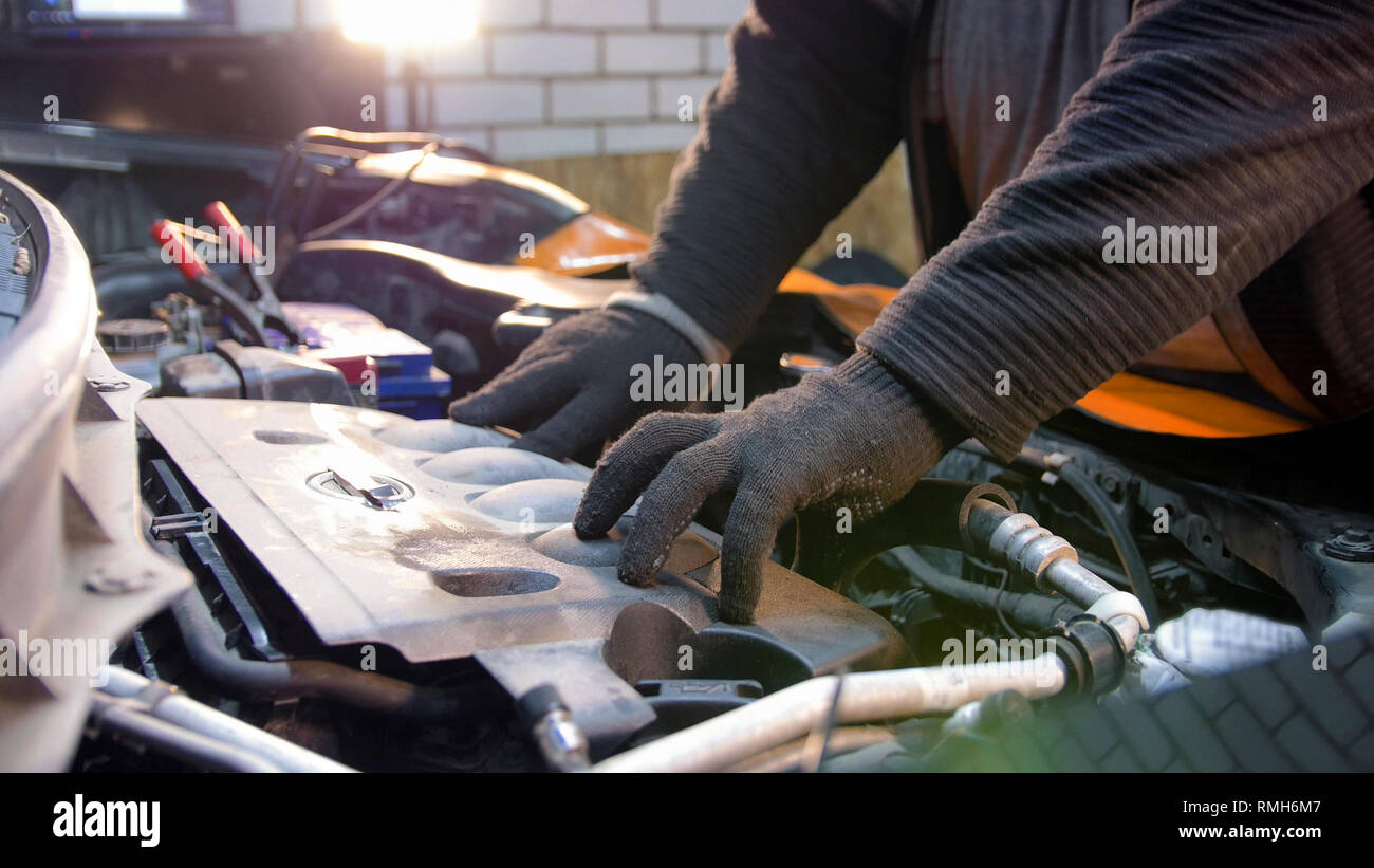 Car service. Mechanic man opening top of an engine Stock Photo - Alamy