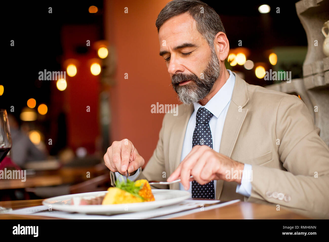 Portrait of handsome senior man eating lunch in restaurant Stock Photo ...