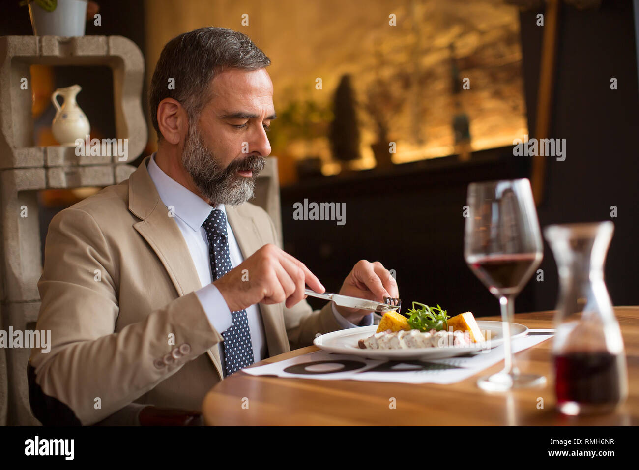Portrait of handsome senior man eating lunch in restaurant Stock Photo ...