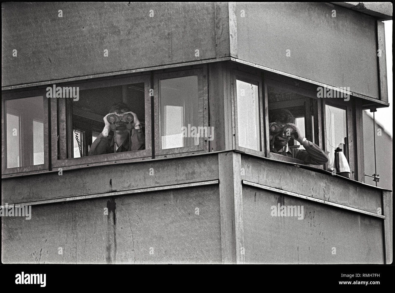 GDR border guards monitor with binoculars the restricted area of ??the ...