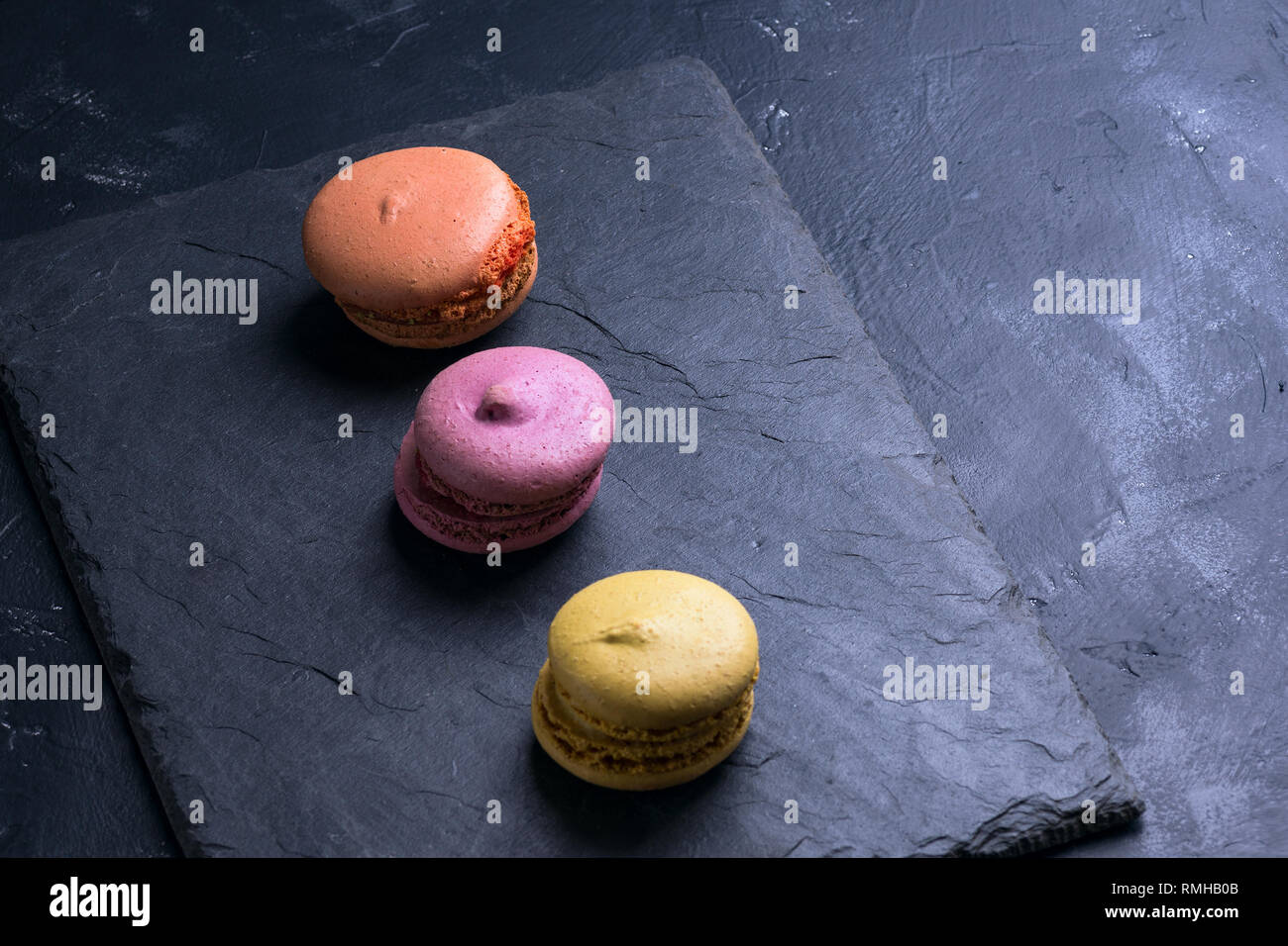 Photo in a dark key French sweet multi-colored macaroni Stock Photo - Alamy