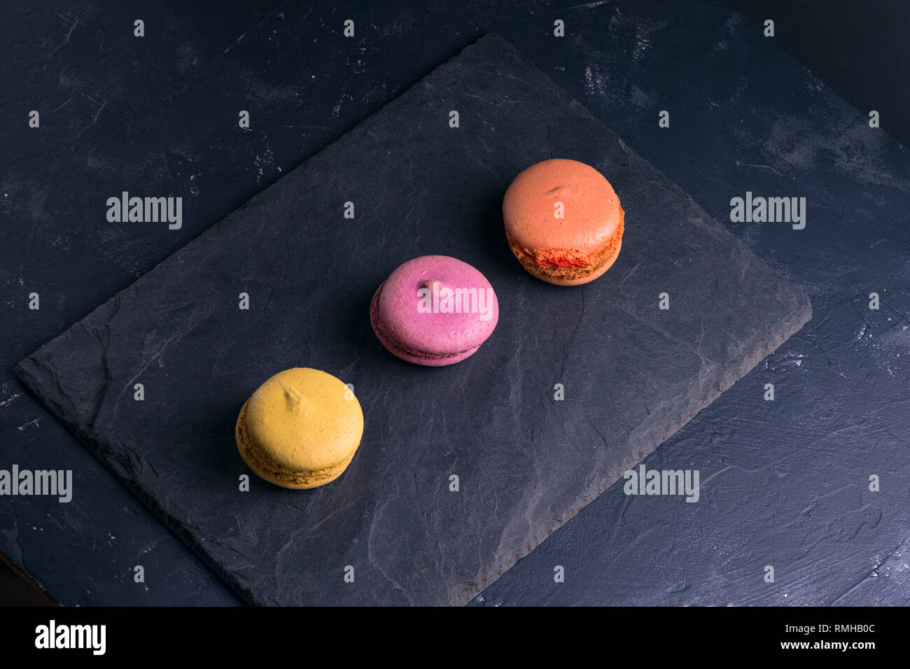 Photo in a dark key French sweet multi-colored macaroni Stock Photo - Alamy
