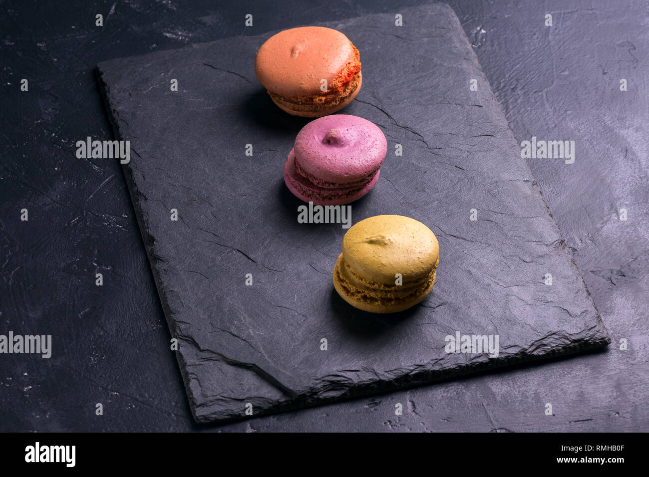 Photo in a dark key French sweet multi-colored macaroni Stock Photo - Alamy