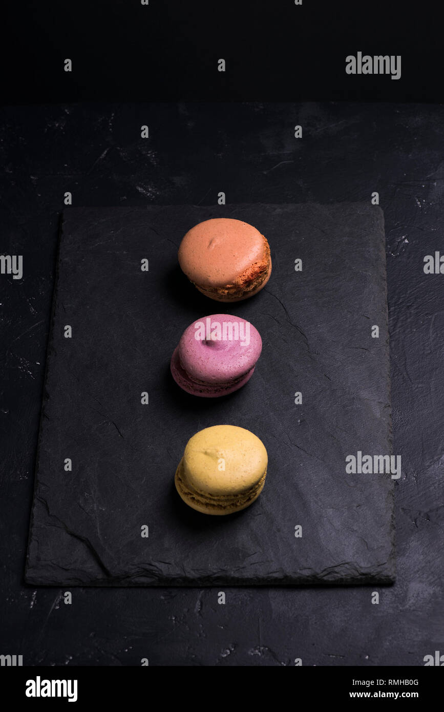 Photo in a dark key French sweet multi-colored macaroni Stock Photo - Alamy