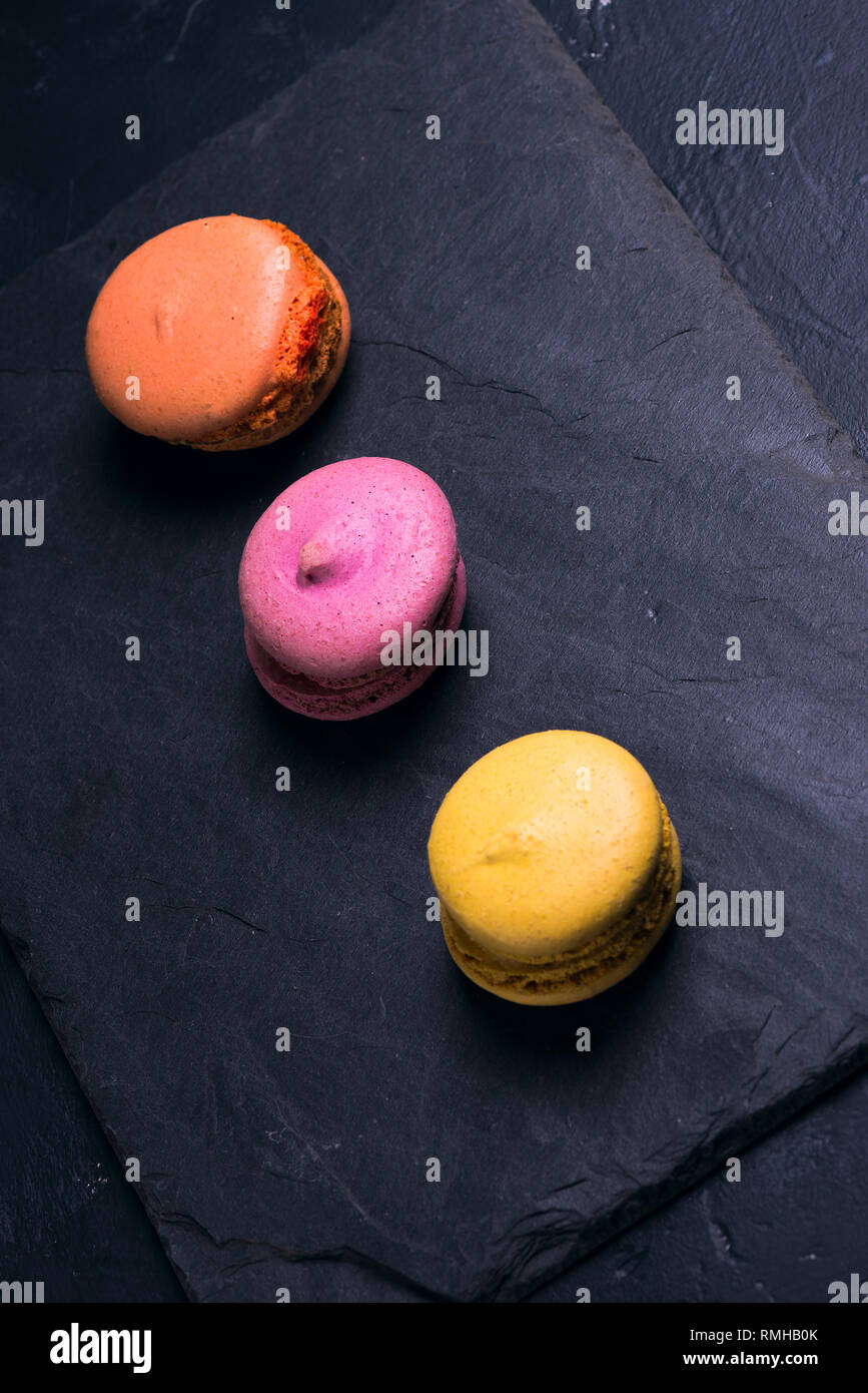 Photo in a dark key French sweet multi-colored macaroni Stock Photo - Alamy