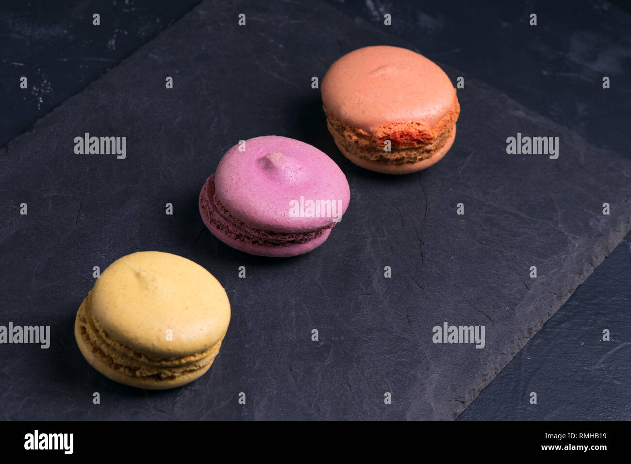 Photo in a dark key French sweet multi-colored macaroni Stock Photo - Alamy