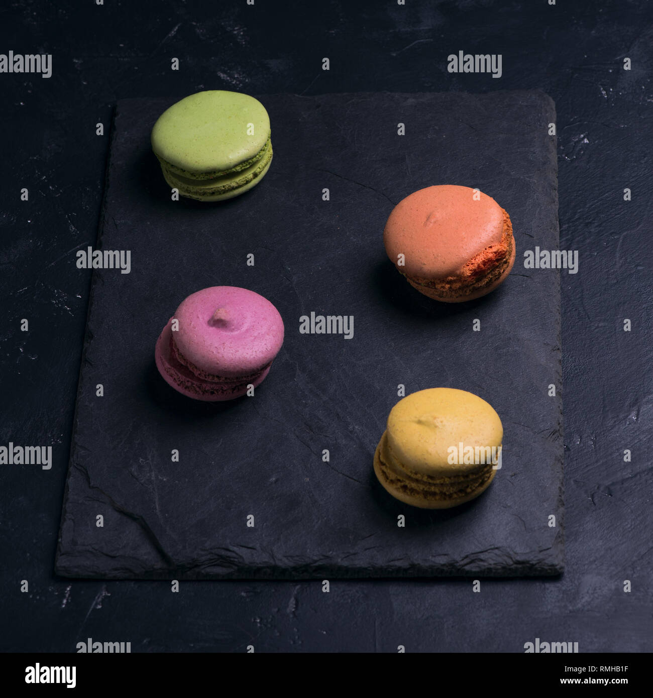 Photo in a dark key French sweet multi-colored macaroni Stock Photo - Alamy