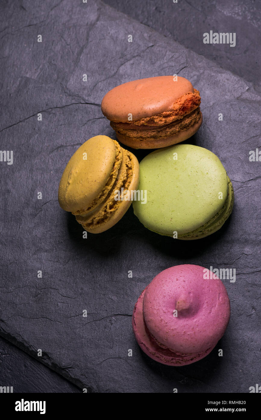 Photo in a dark key French sweet multi-colored macaroni Stock Photo - Alamy