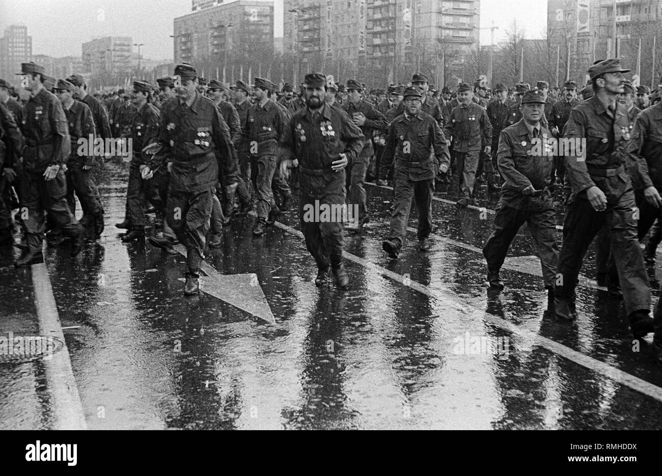 Germany, Berlin, 1 May, 1987: Combat groups run from the heavy rain at ...