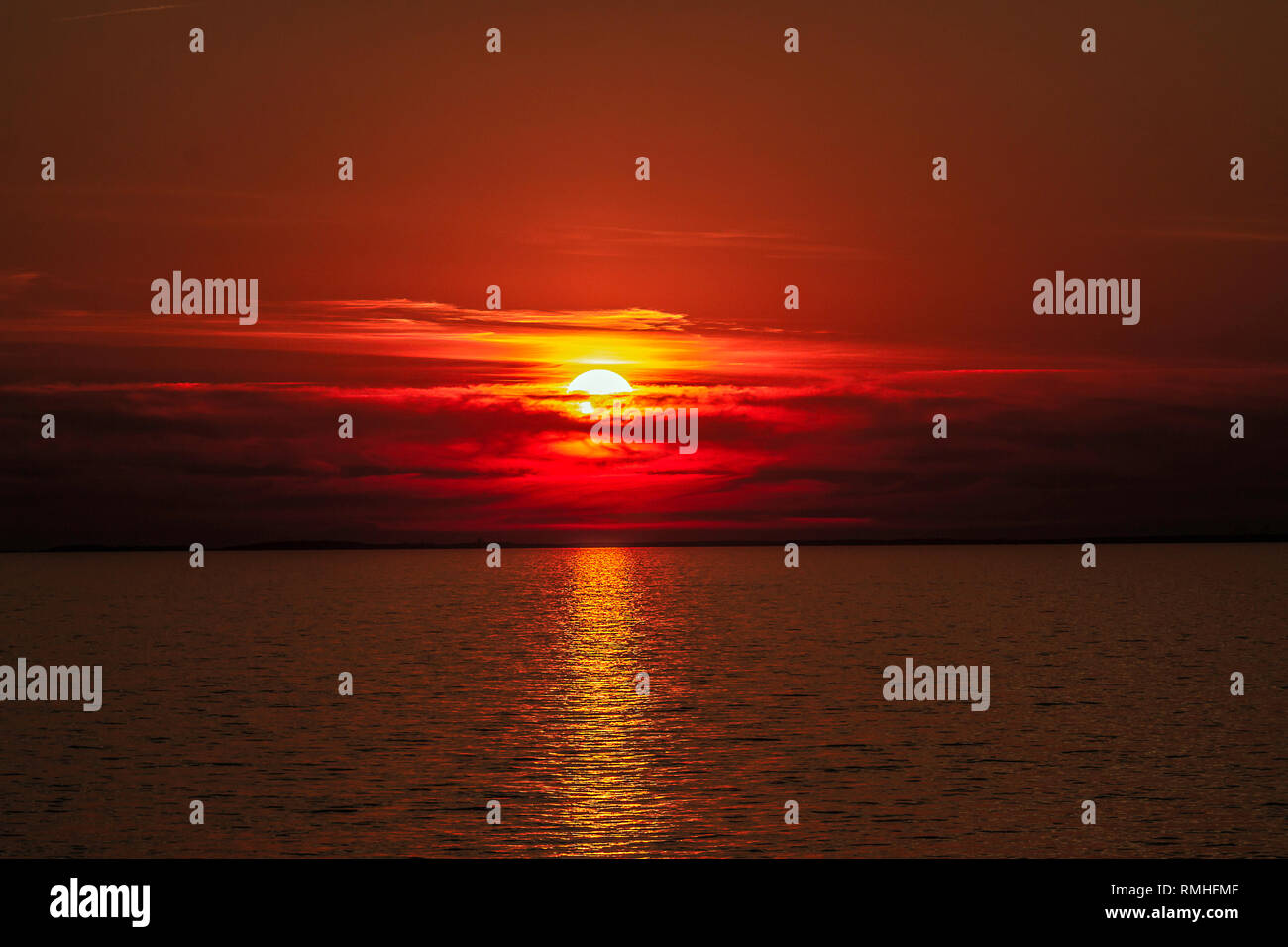 The red sunset sky with sun and clouds Stock Photo - Alamy