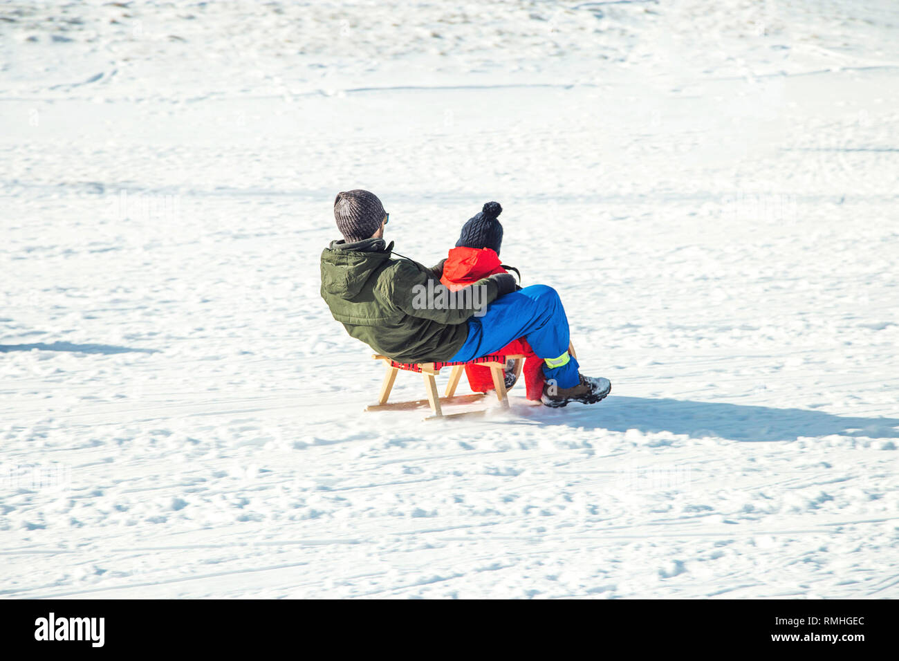 Happy father and his son enjoying sledding ride. Happy family with sled ...