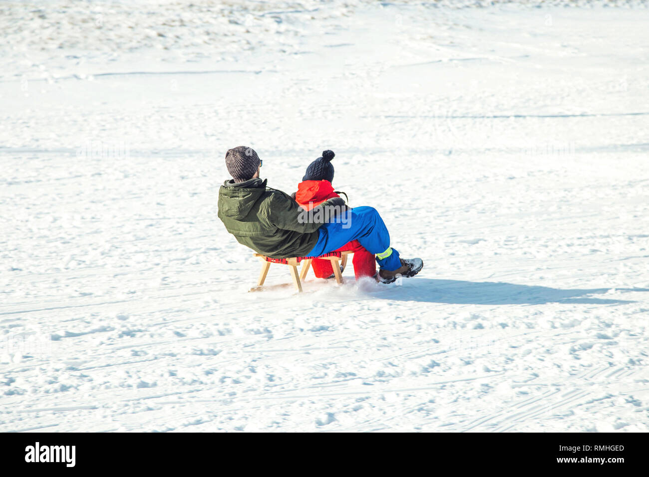 Happy father and his son enjoying sledding ride. Happy family with sled ...