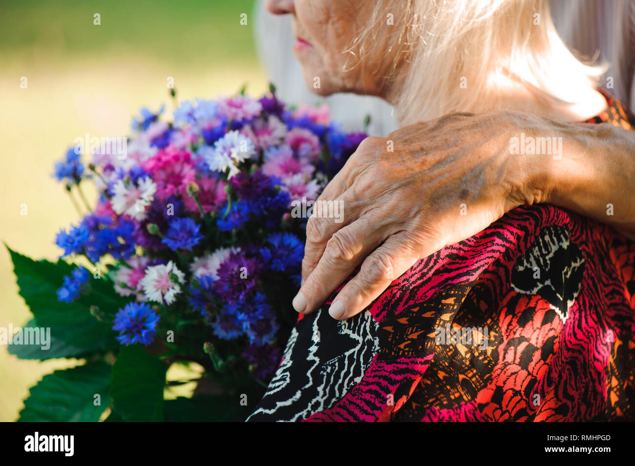 Two old people relax and hug each other in a park Stock Photo - Alamy