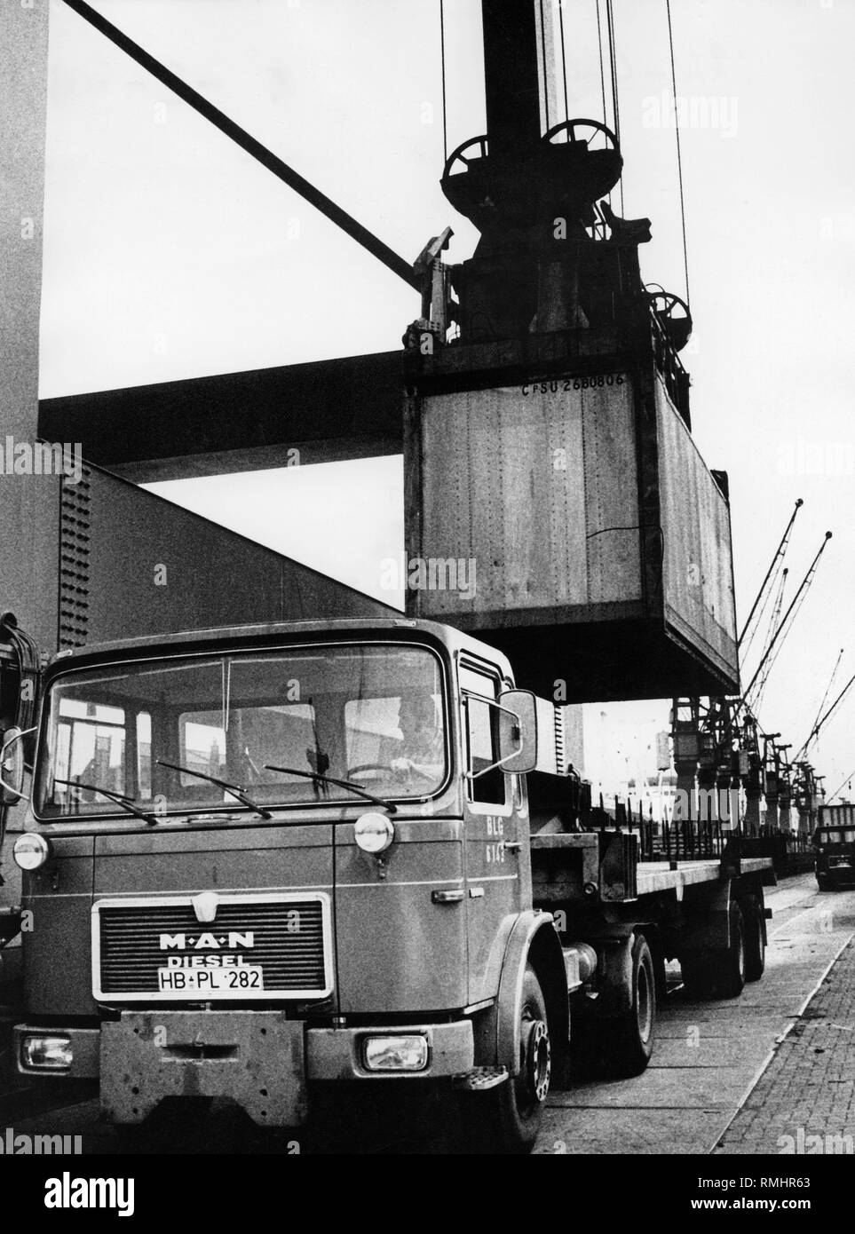 A crane loads containers onto a MAN F7 truck in Bremerhaven Stock Photo ...