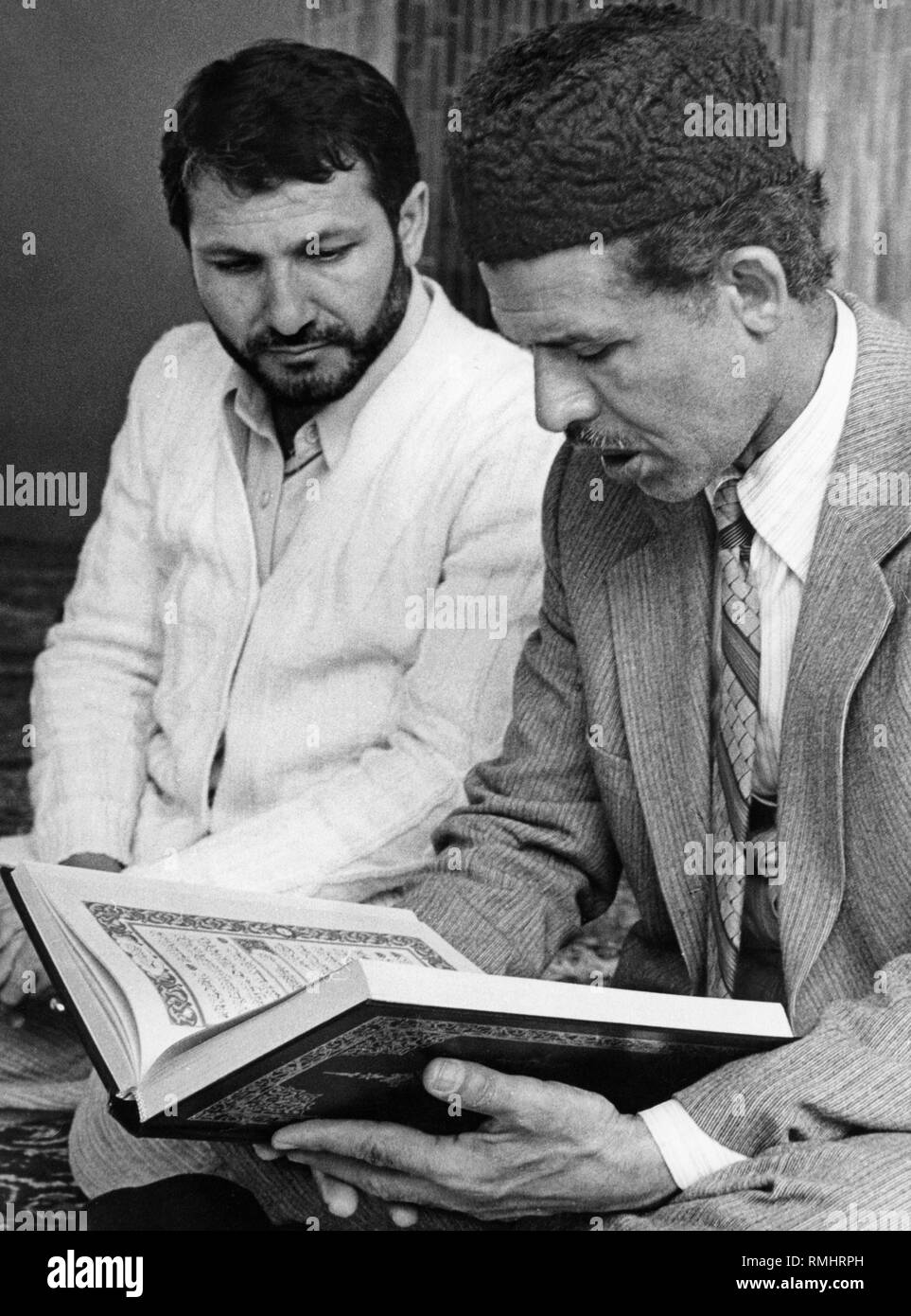 Two migrants with Turkish roots read in the Koran. Undated photo, early ...