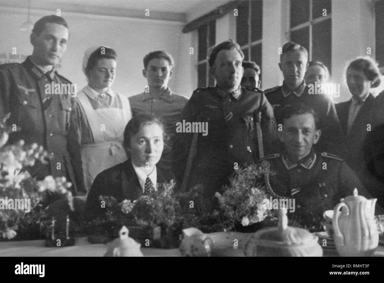 A corporal of the Wehrmacht and his future wife (sitting at the table ...