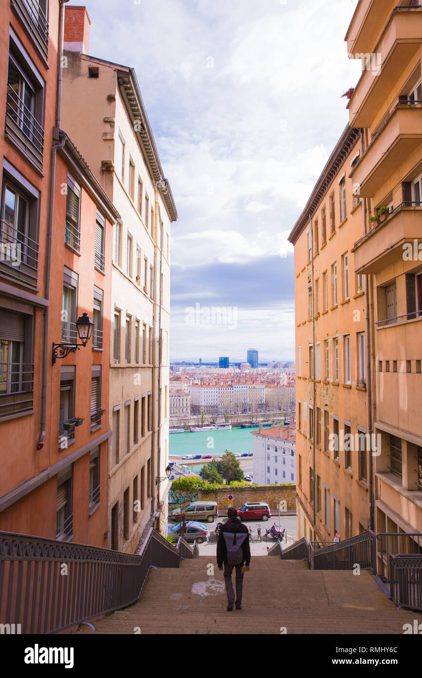 People walk along a set of stairs that lead down to the Rhône river in ...