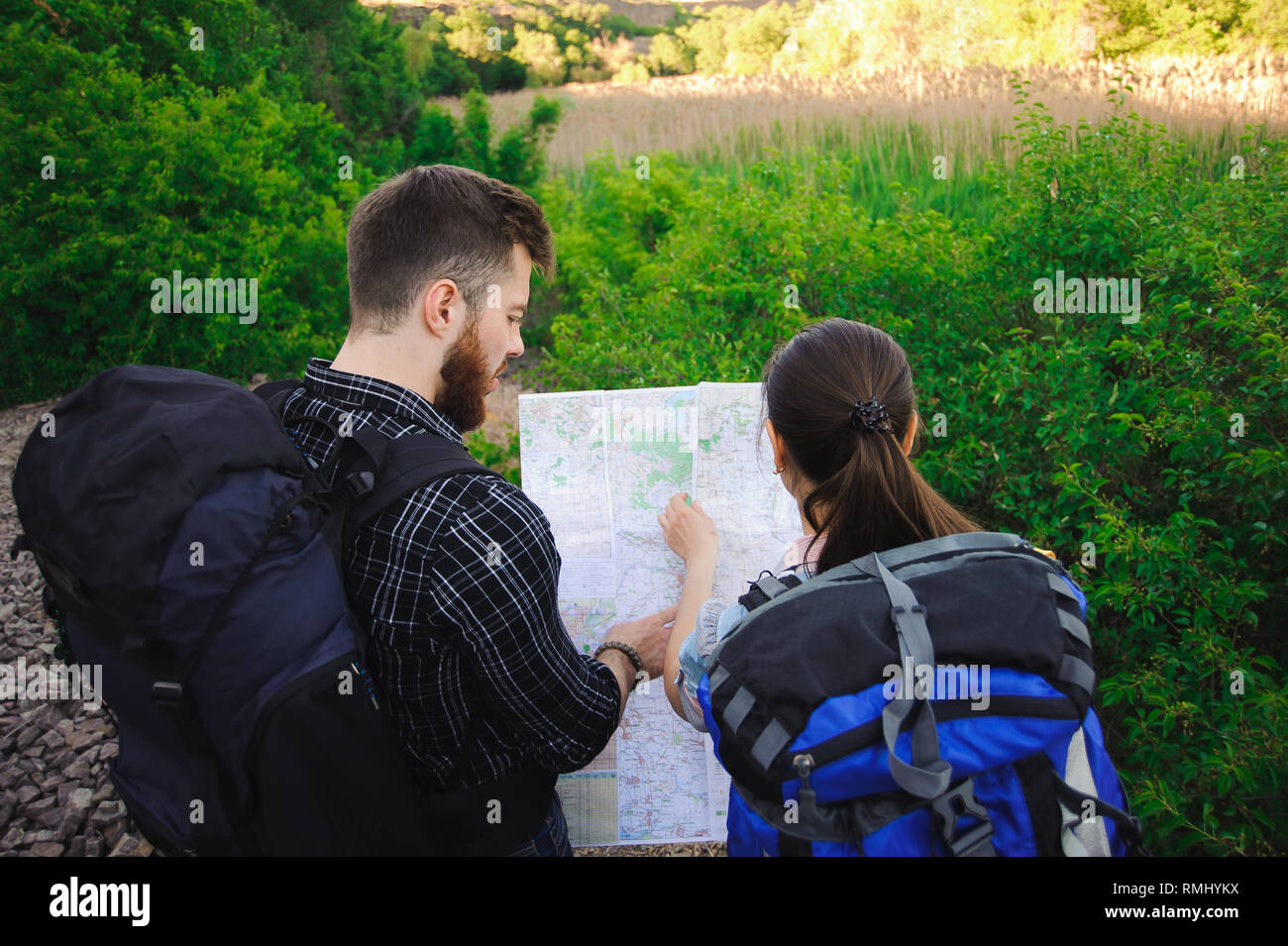 Back side of travelers searching right direction on map, freedom Stock ...