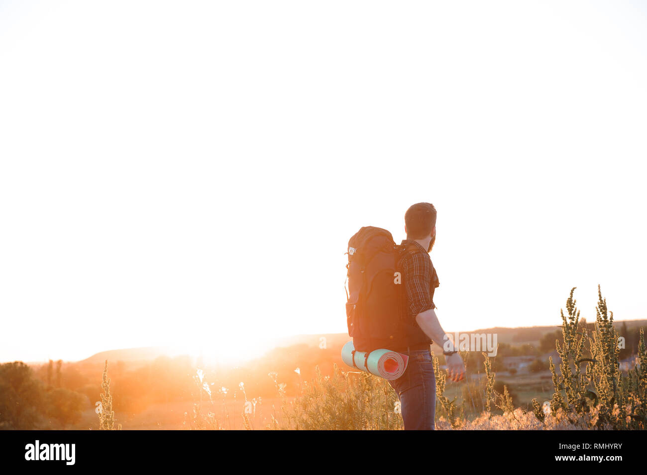 Young man is looking at sunset. Traveller with backpack Stock Photo - Alamy