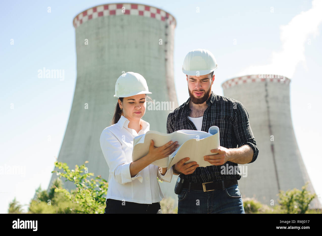 two engineers standing at electricity station, discussing plan Stock ...