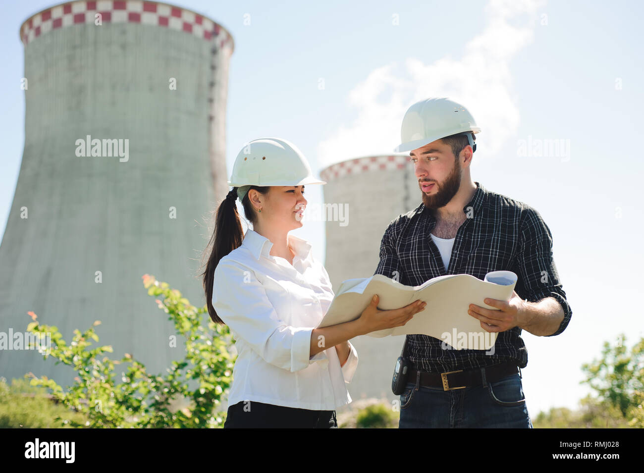 two engineers standing at electricity station, discussing plan Stock ...