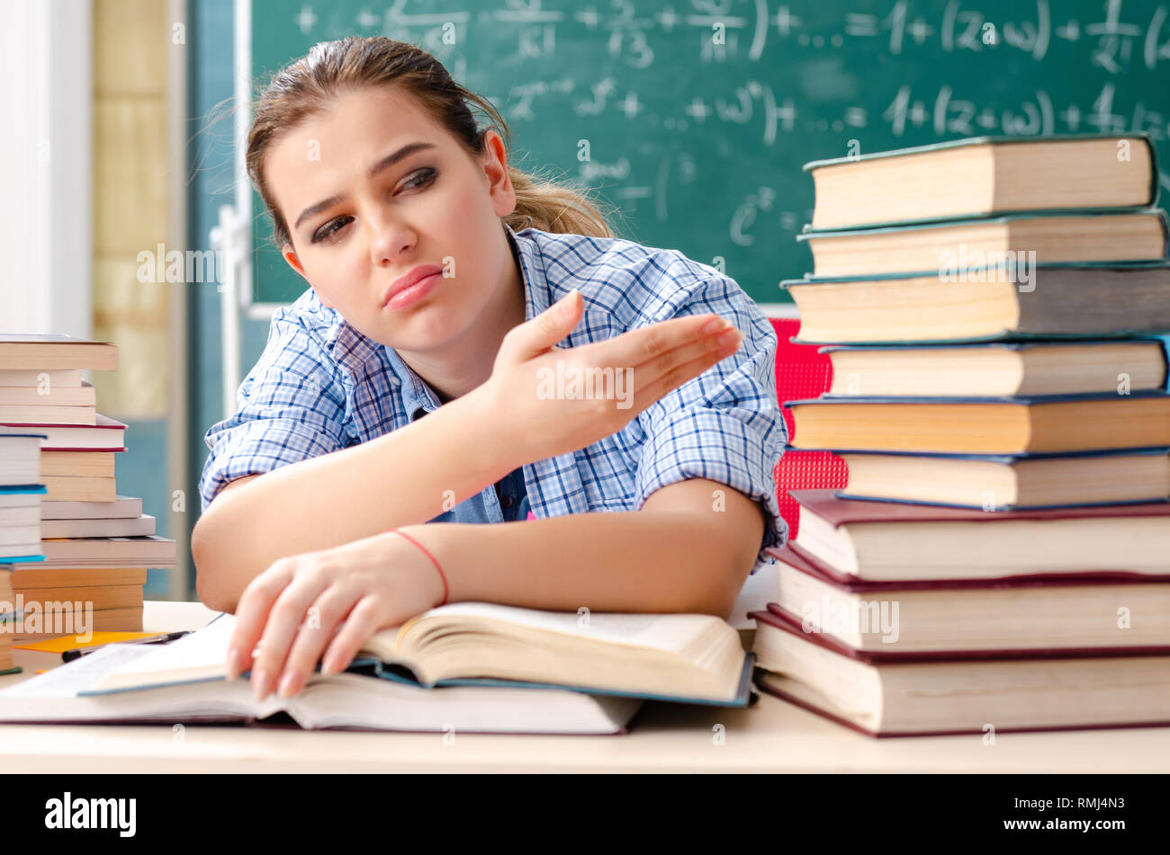 Female student with many books sitting in the classroom Stock Photo - Alamy