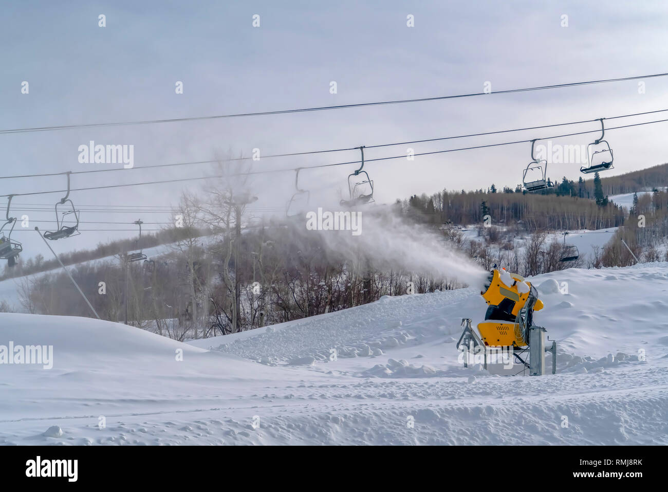 Snow canon and chair lifts on snowy mountain Stock Photo - Alamy