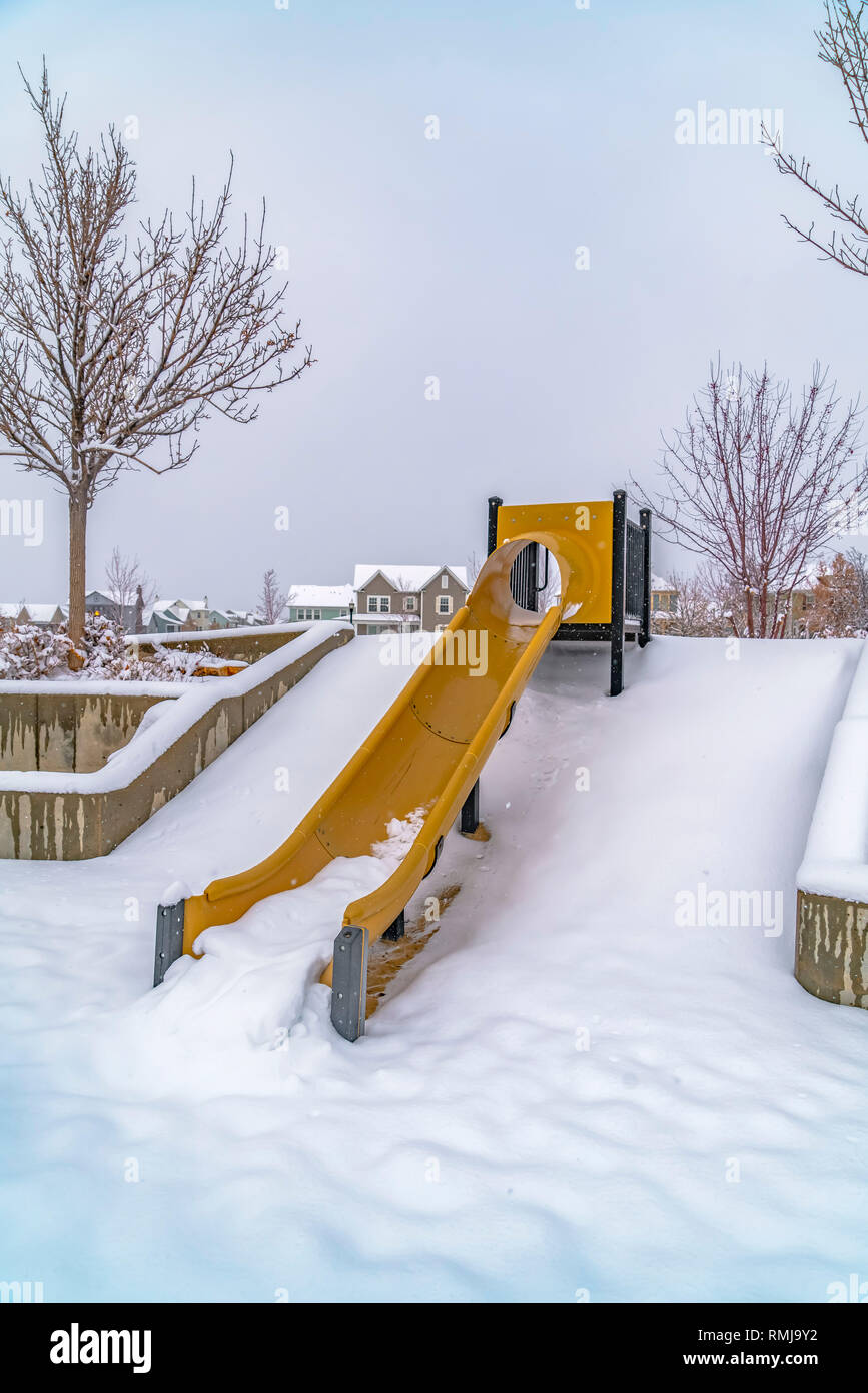 Yellow slide on snowy playground in Daybreak Utah Stock Photo - Alamy