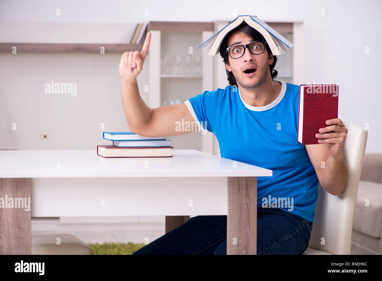 Young handsome student studying at home Stock Photo - Alamy