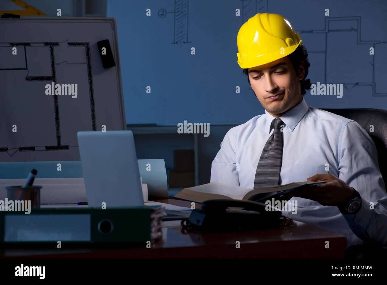 Young construction architect working on project at night Stock Photo ...