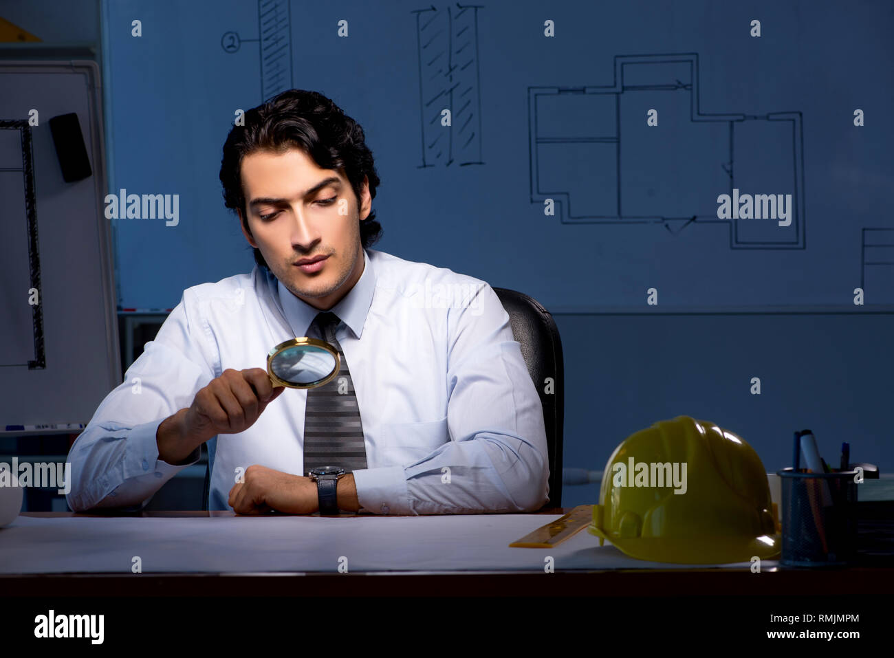 Young construction architect working on project at night Stock Photo ...