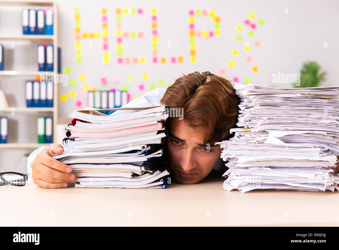 Young employee suffering from excessive work Stock Photo - Alamy
