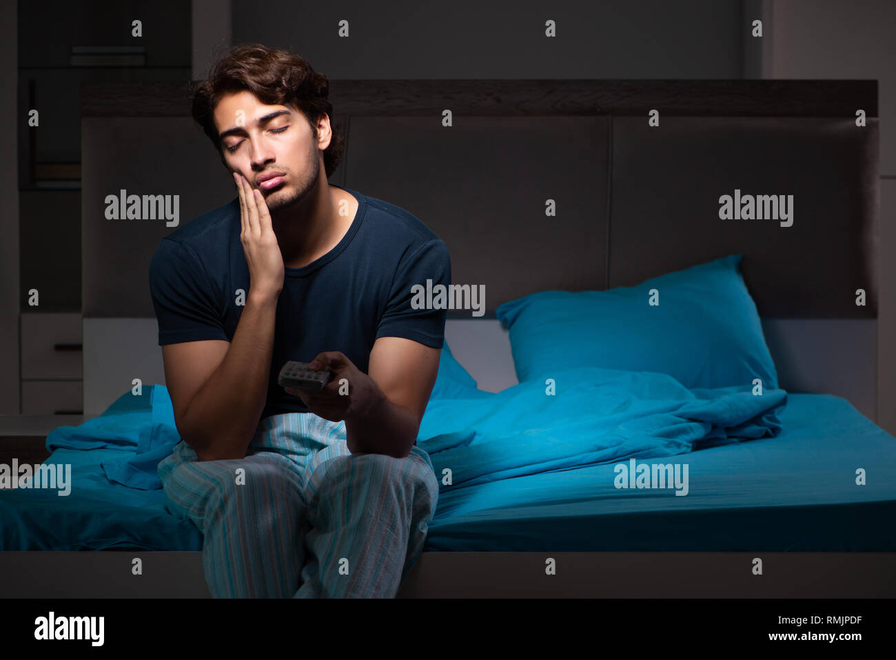 Man watching tv at night in bed Stock Photo - Alamy
